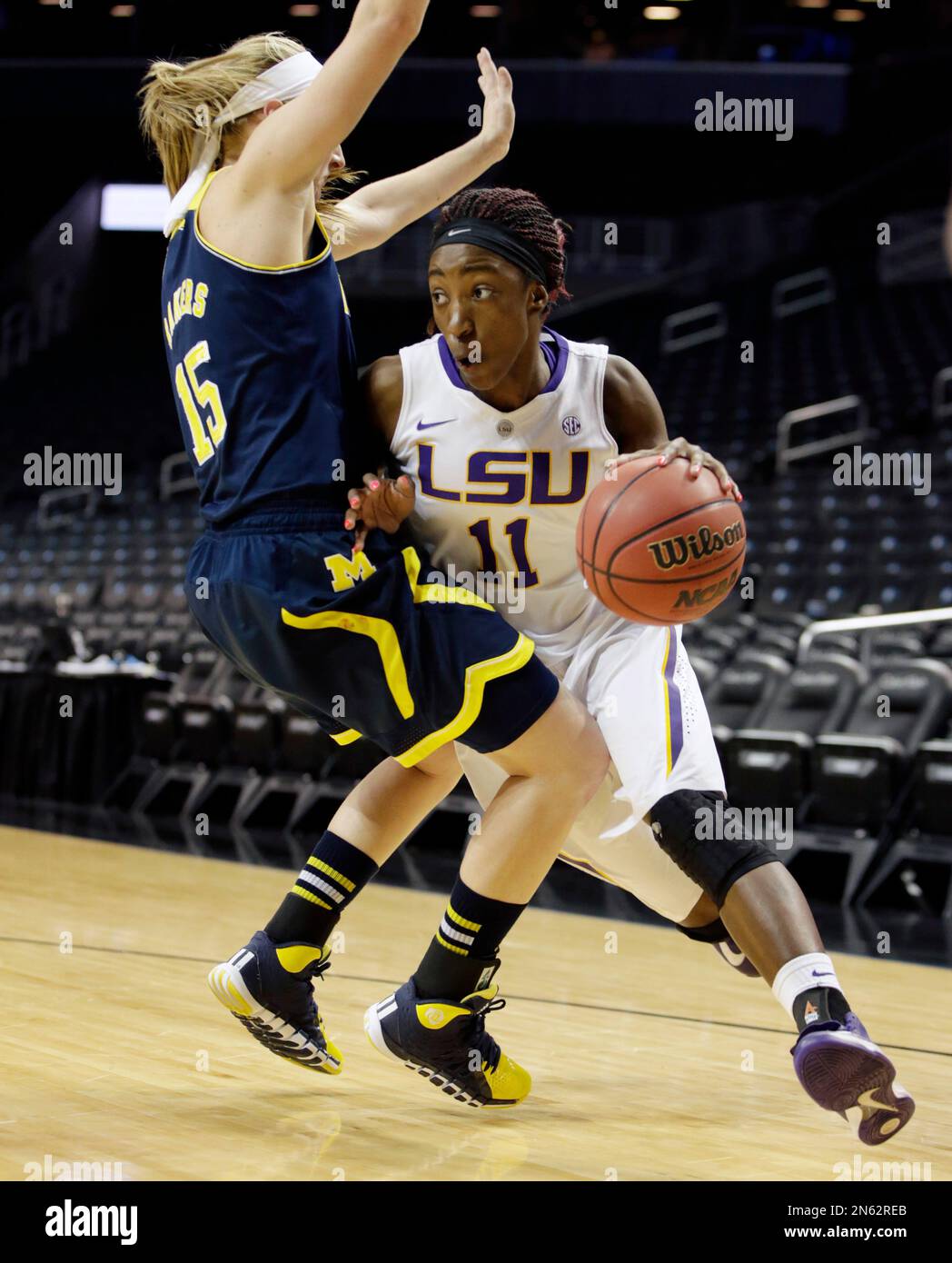 LSU guard Raigyne Moncrief (11) drives past Michigan guard Paige Rakers ...
