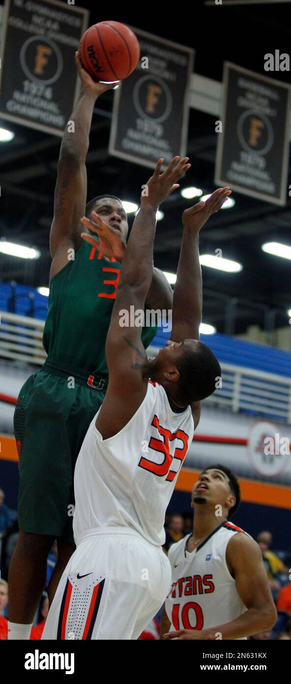 Miami forward James Kelly, left, shoots over Cal State Fullerton ...