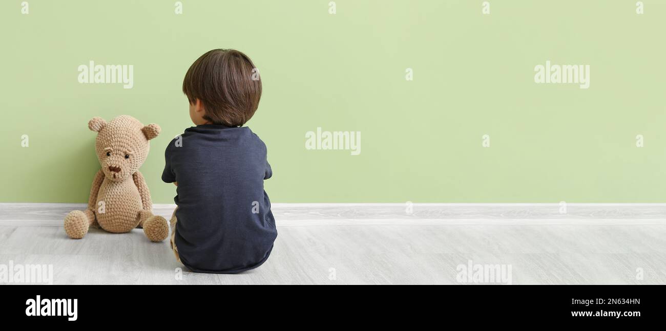 Sad little boy with autistic disorder sitting near wall. Banner for ...