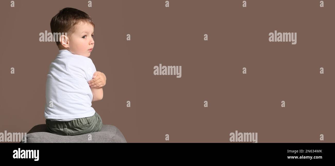 Sad little boy with autistic disorder on brown background with space ...