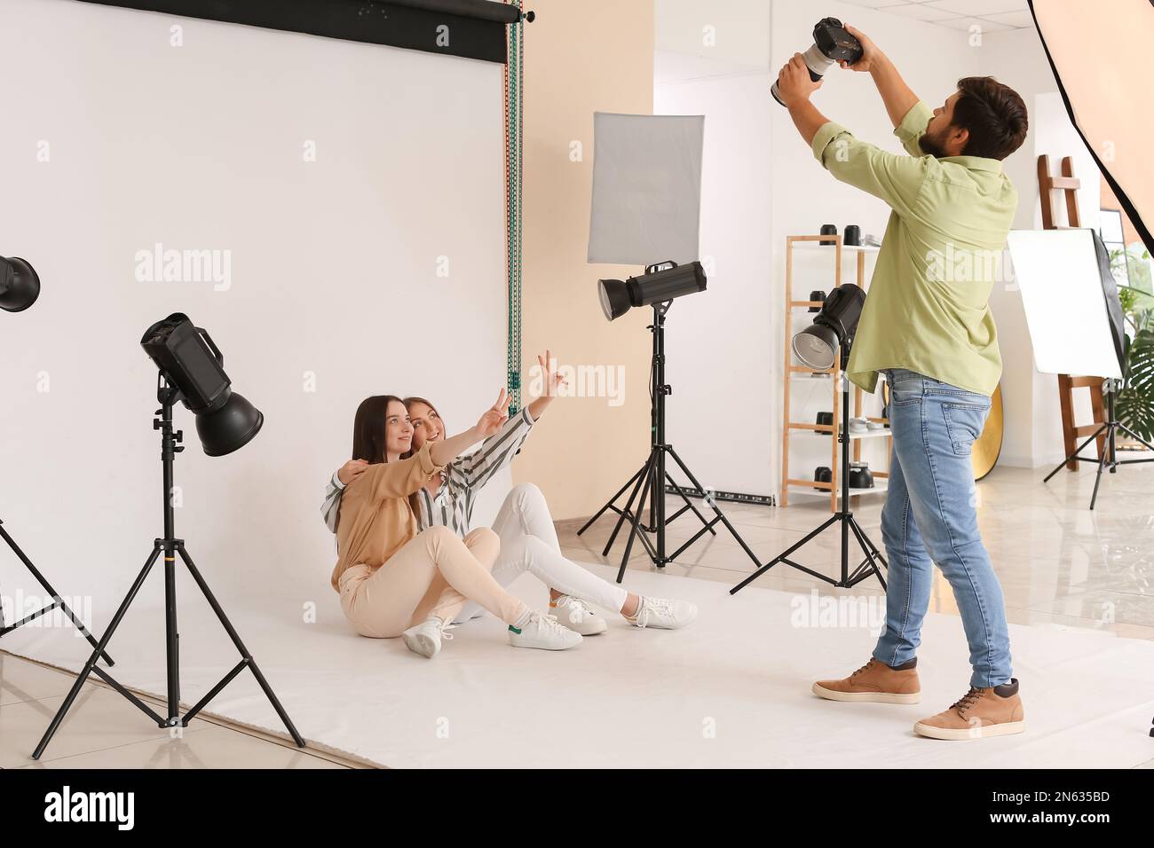 Male photographer taking picture of beautiful models in studio Stock ...