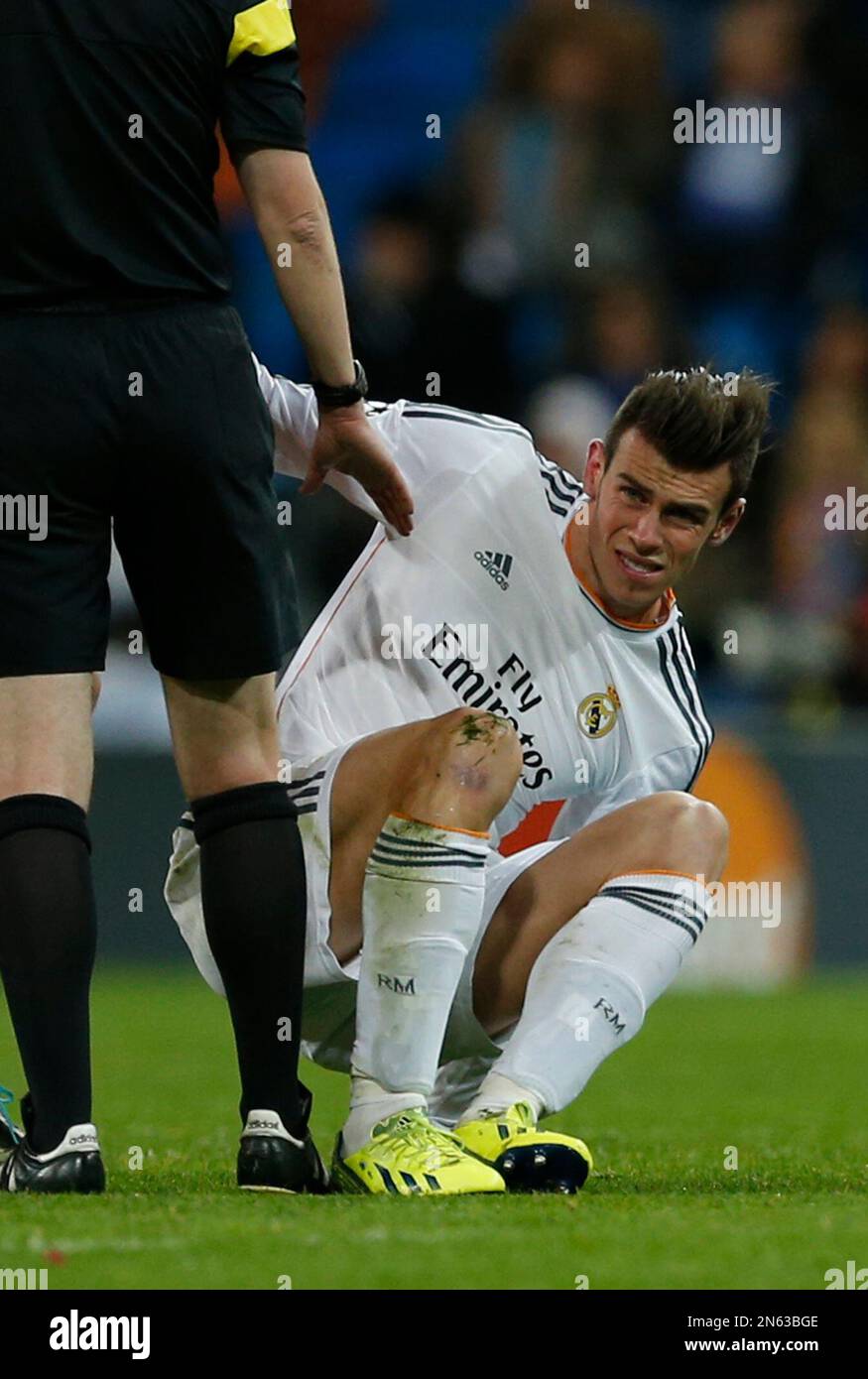 Real's Gareth Bale, is helped up by the referee during a Group B ...