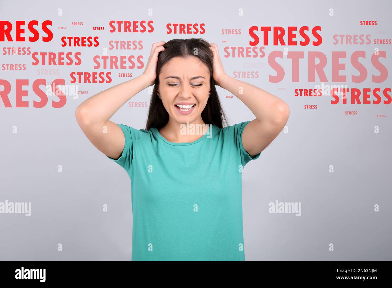 Stressed young woman and text on light grey background Stock Photo - Alamy