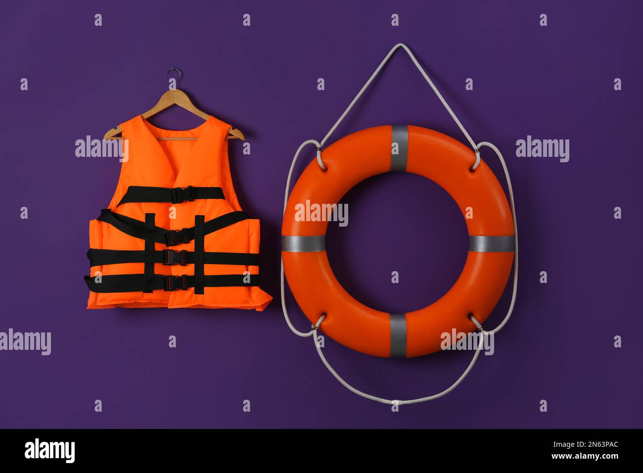 Orange life jacket and lifebuoy on violet background. Rescue equipment Stock Photo - Alamy