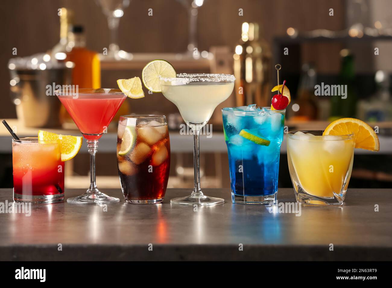 Different delicious cocktails on grey table in bar Stock Photo - Alamy