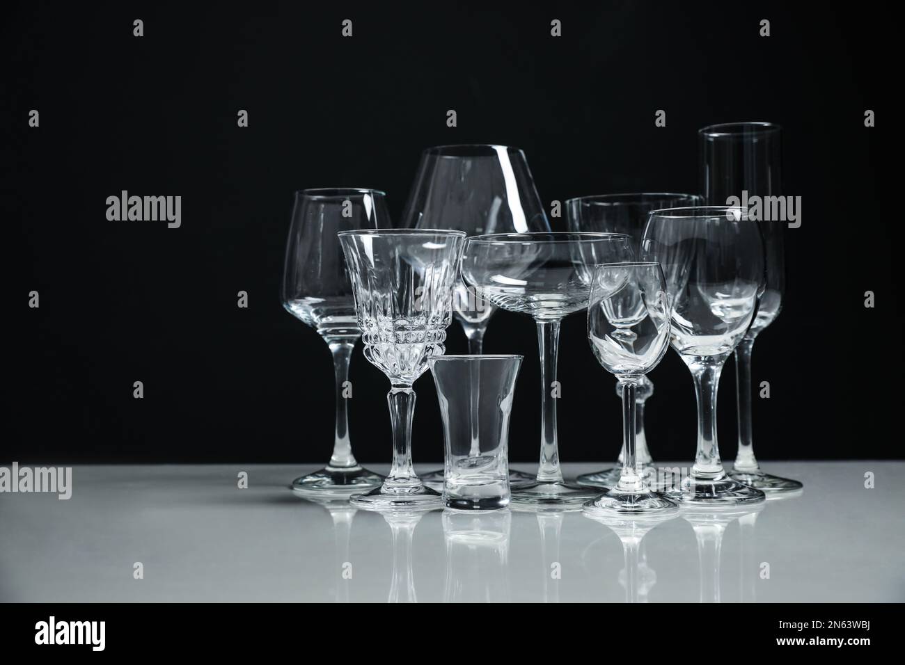 Set of bar glassware on white table against black background Stock ...