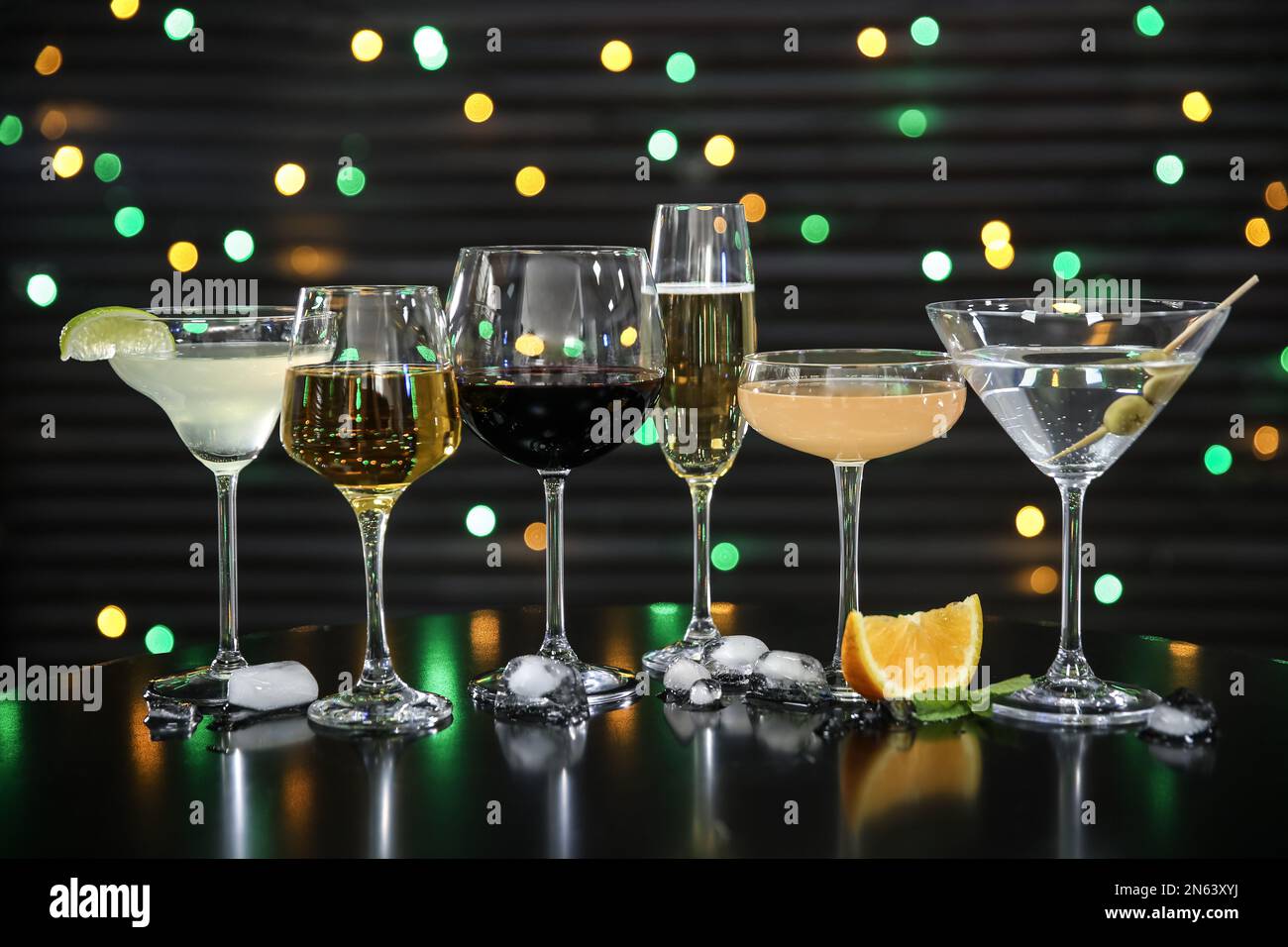 Many different alcoholic drinks on table against dark background with ...