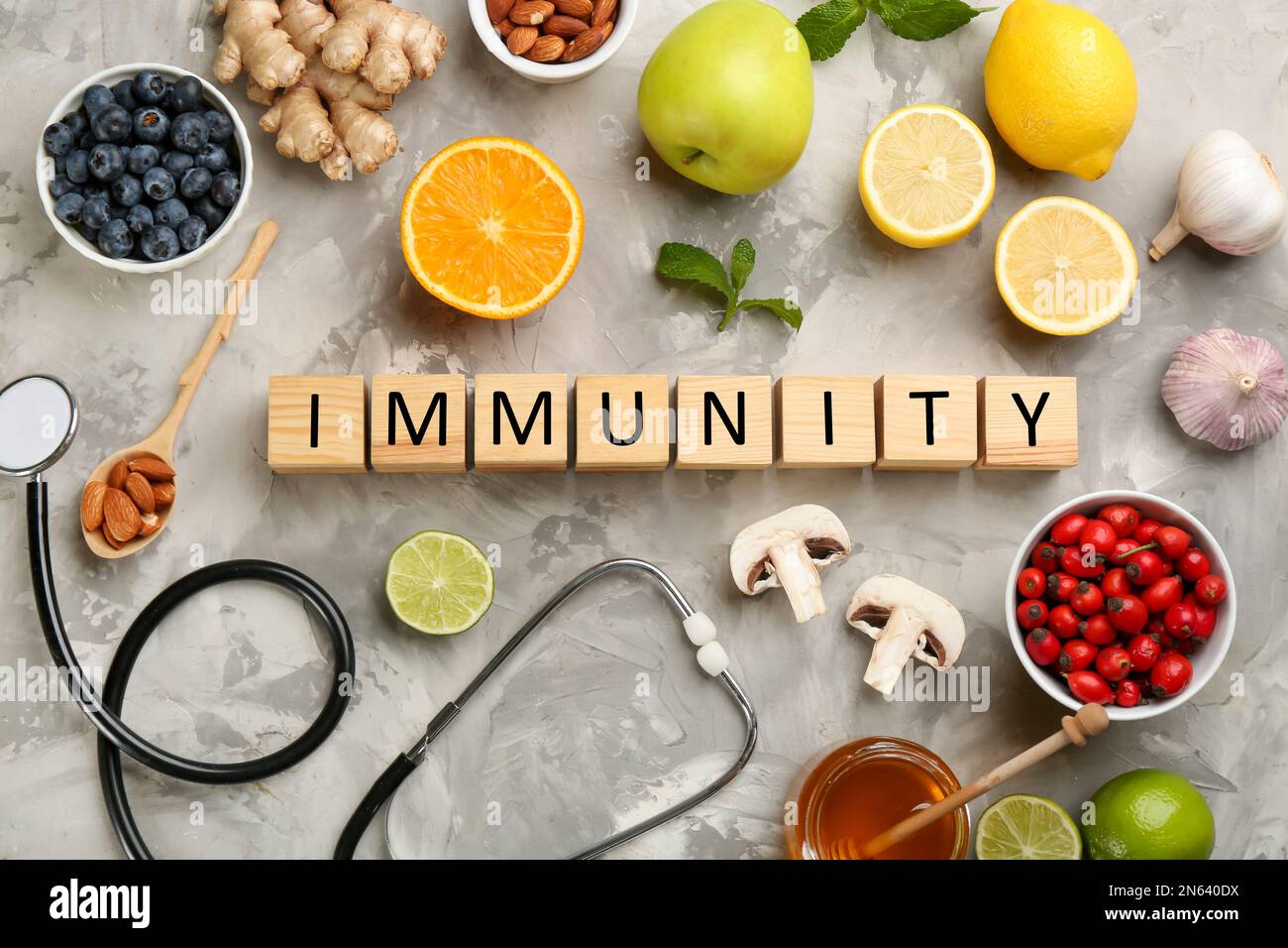 Cubes with word Immunity, stethoscope and fresh products on grey table ...