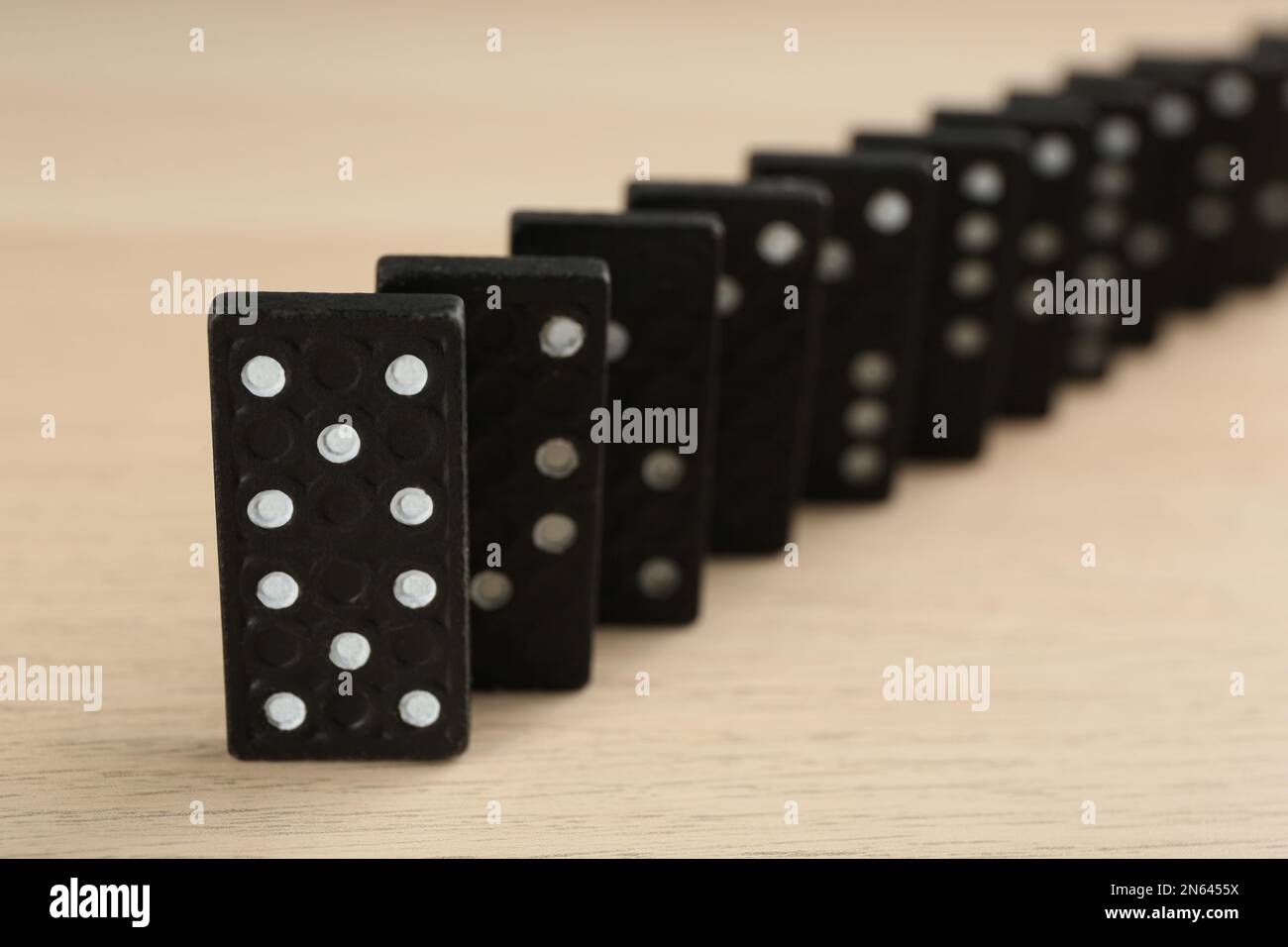 Black domino tiles with white pips on wooden table, closeup Stock Photo ...