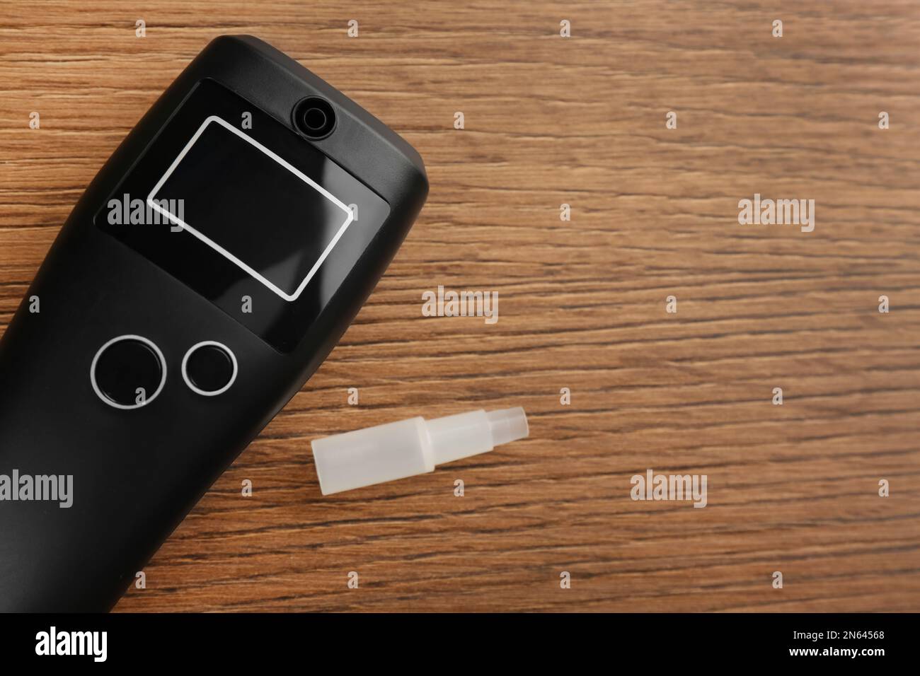 Modern breathalyzer with blank screen and mouthpiece on wooden table ...