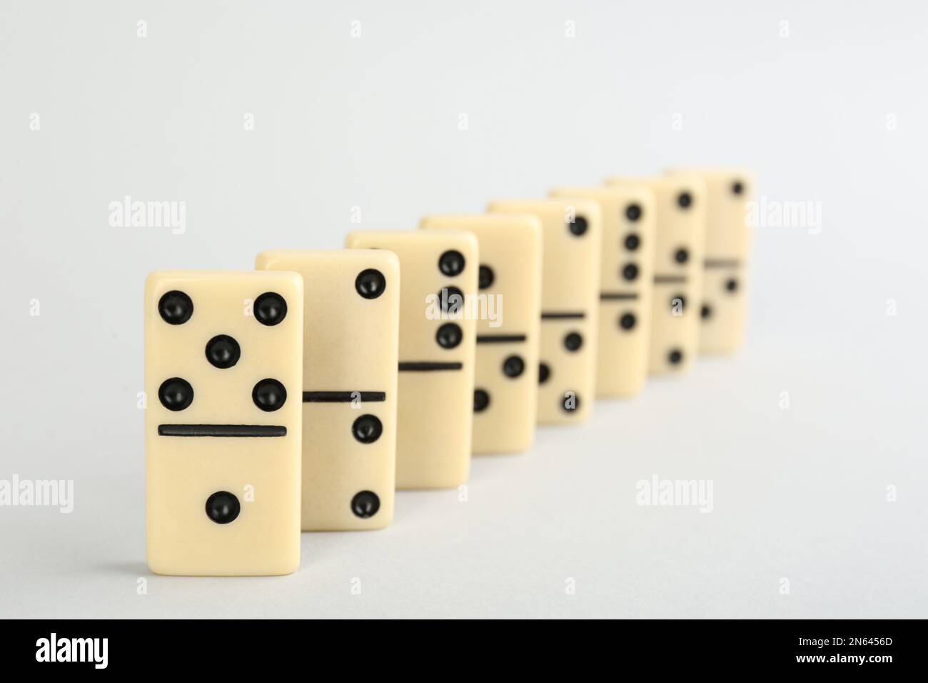 Row of domino tiles on white background Stock Photo - Alamy