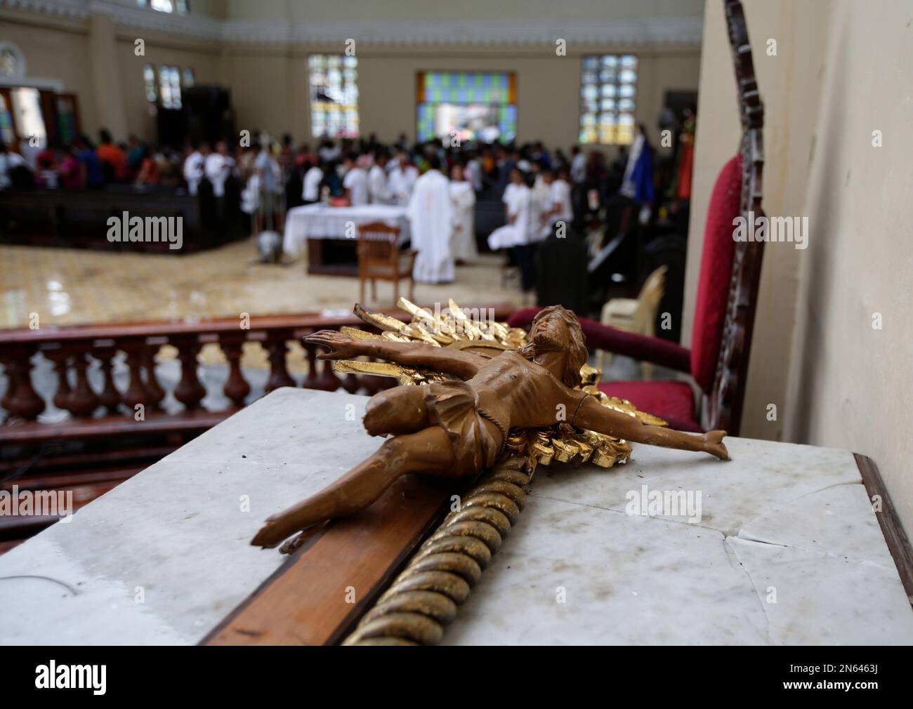 A broken wooden statue of Jesus Christ is placed on an altar as typhoon ...