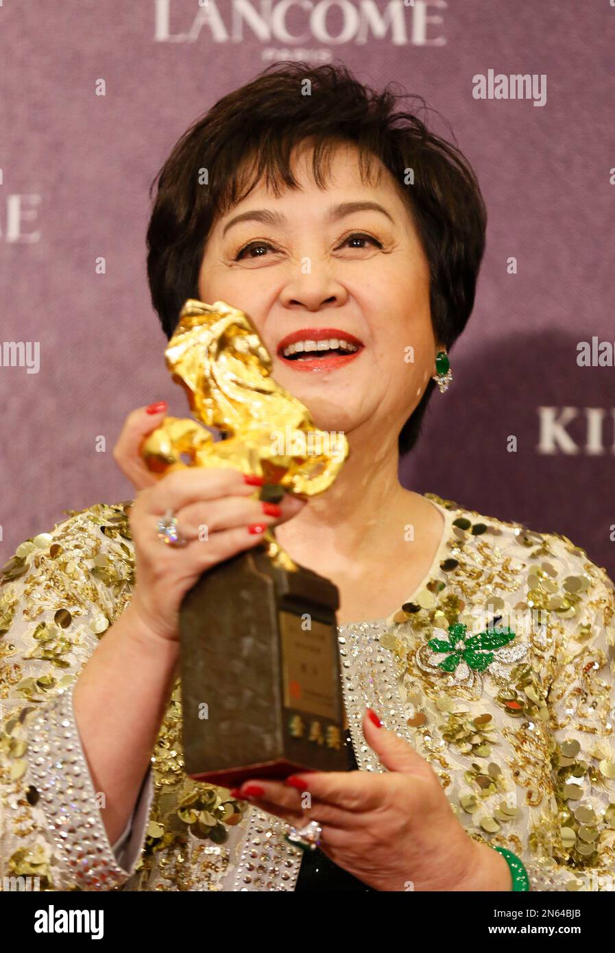Taiwanese actress Chen Chen holds her awards and poses for the media ...