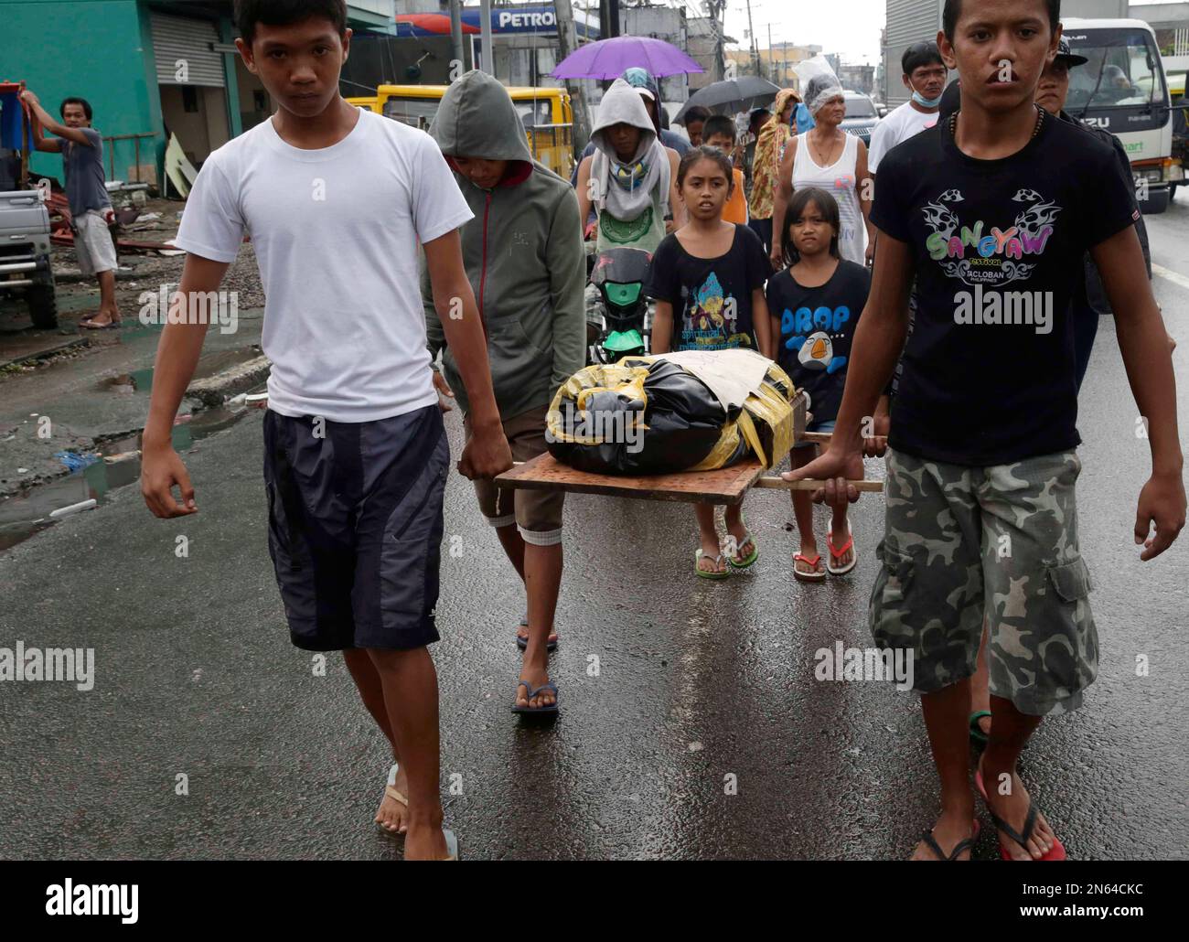 Relatives carry the body of three-year-old typhoon victim Athena Mae ...