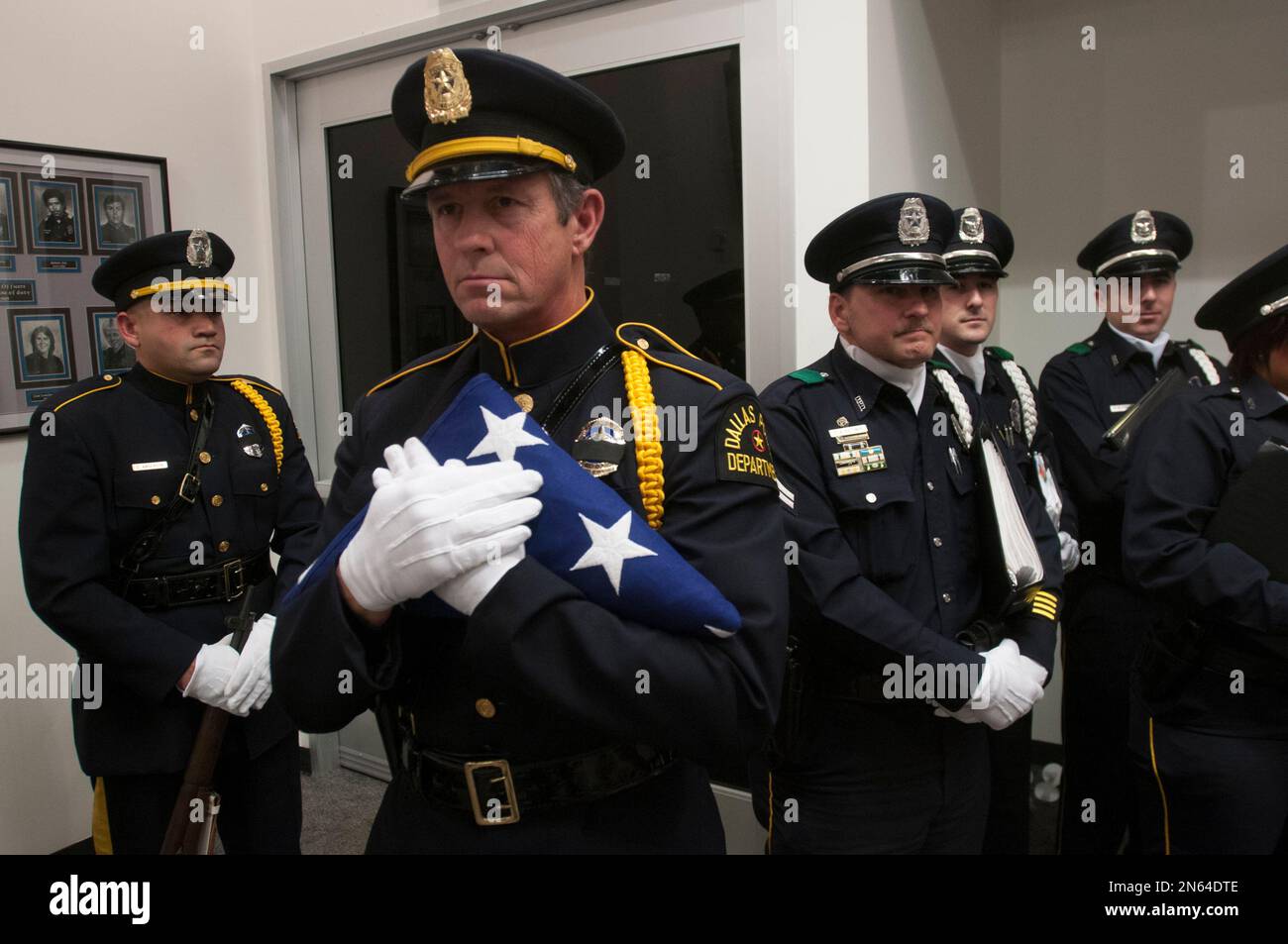 Dallas Police Officer Joe Denomy holds a flag that was presented to ...