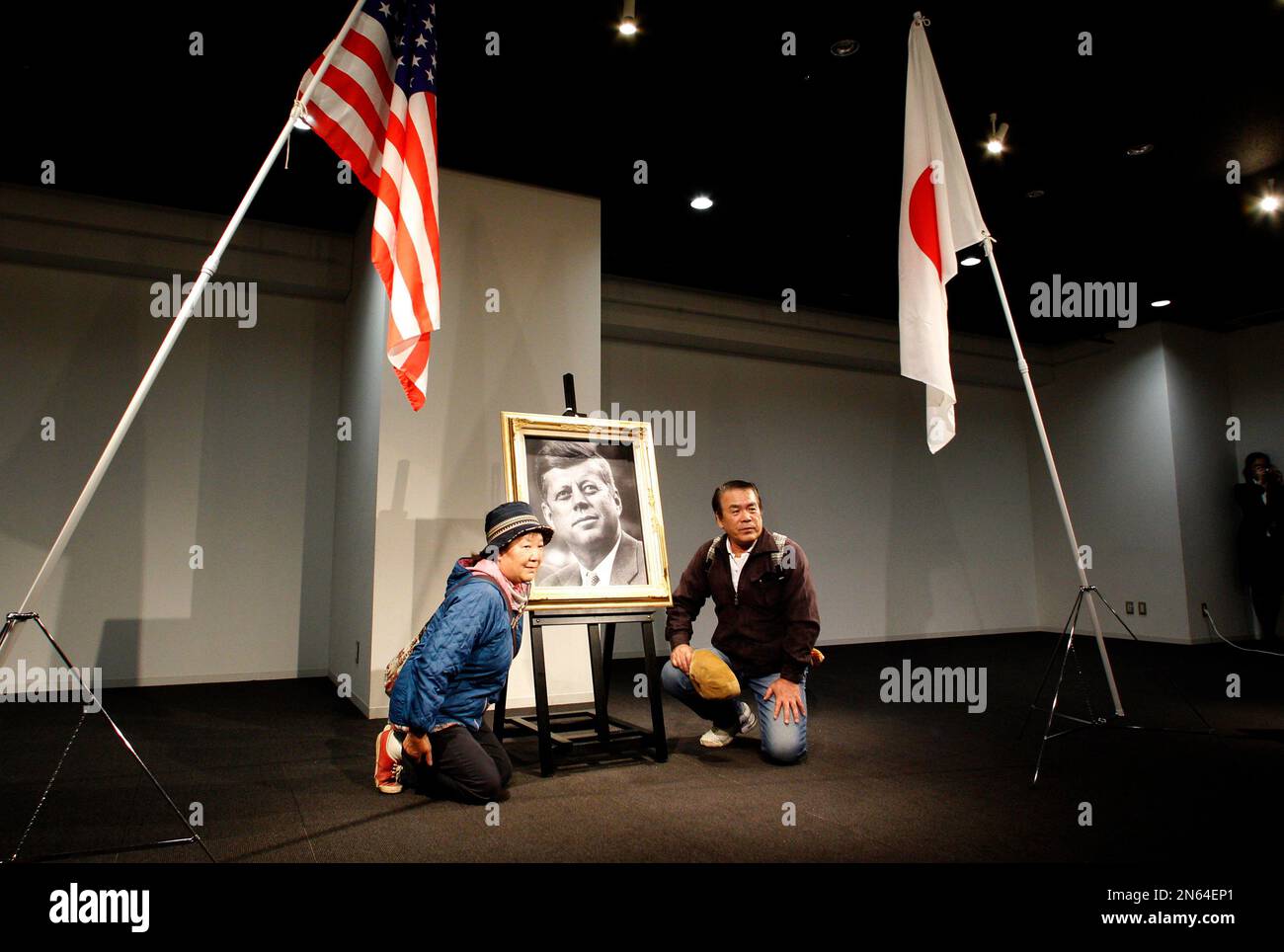 A man and woman pose with a portrait of the late U.S. President John F ...