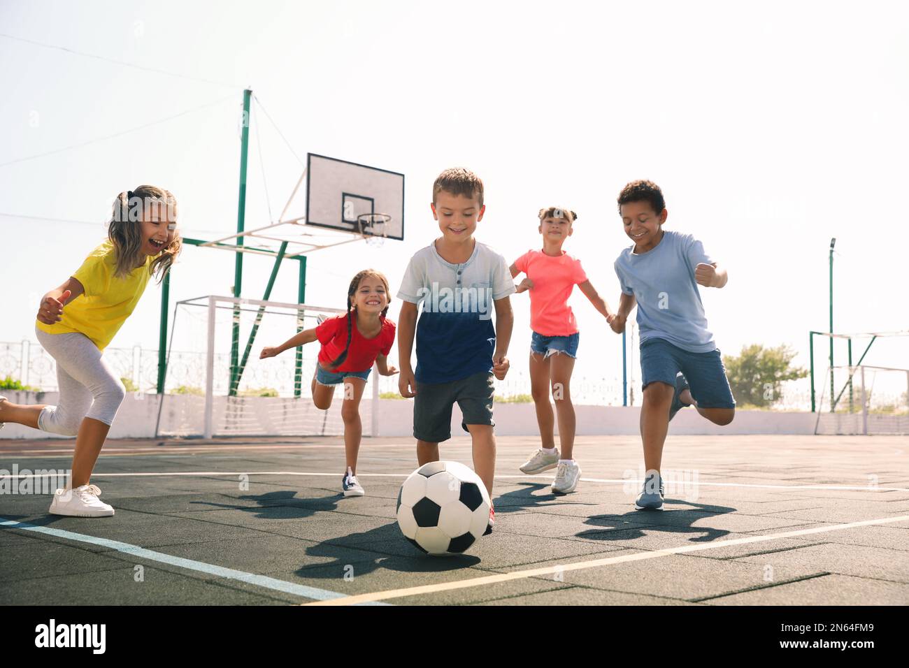 Cute children playing soccer outdoors on sunny day. Summer camp Stock ...
