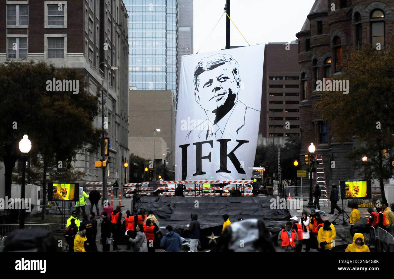 A banner of John F. Kennedy is lowered to the stage before a ceremony ...