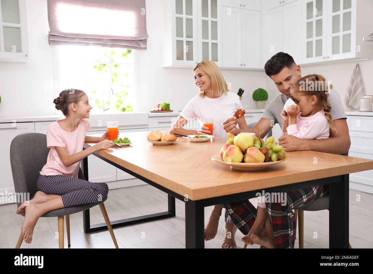 Happy family having breakfast together at table in modern kitchen Stock ...