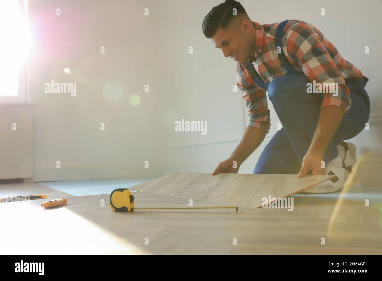 Professional worker installing new parquet flooring indoors Stock Photo ...