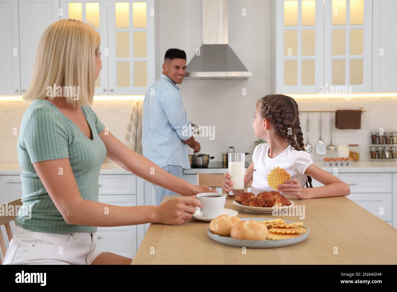 Happy family eating together in modern kitchen Stock Photo - Alamy