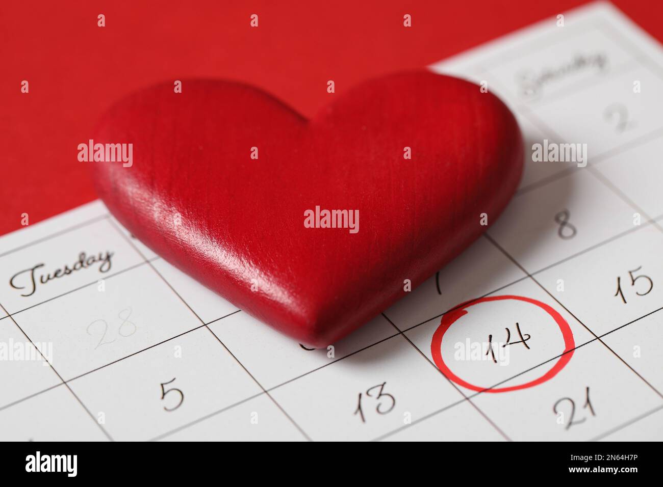 Calendar with marked Valentine's Day and heart on red background ...