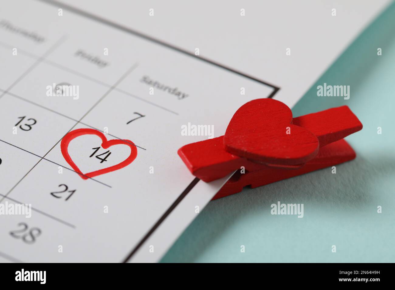 Calendar with marked Valentine's Day and red clothespin on turquoise ...