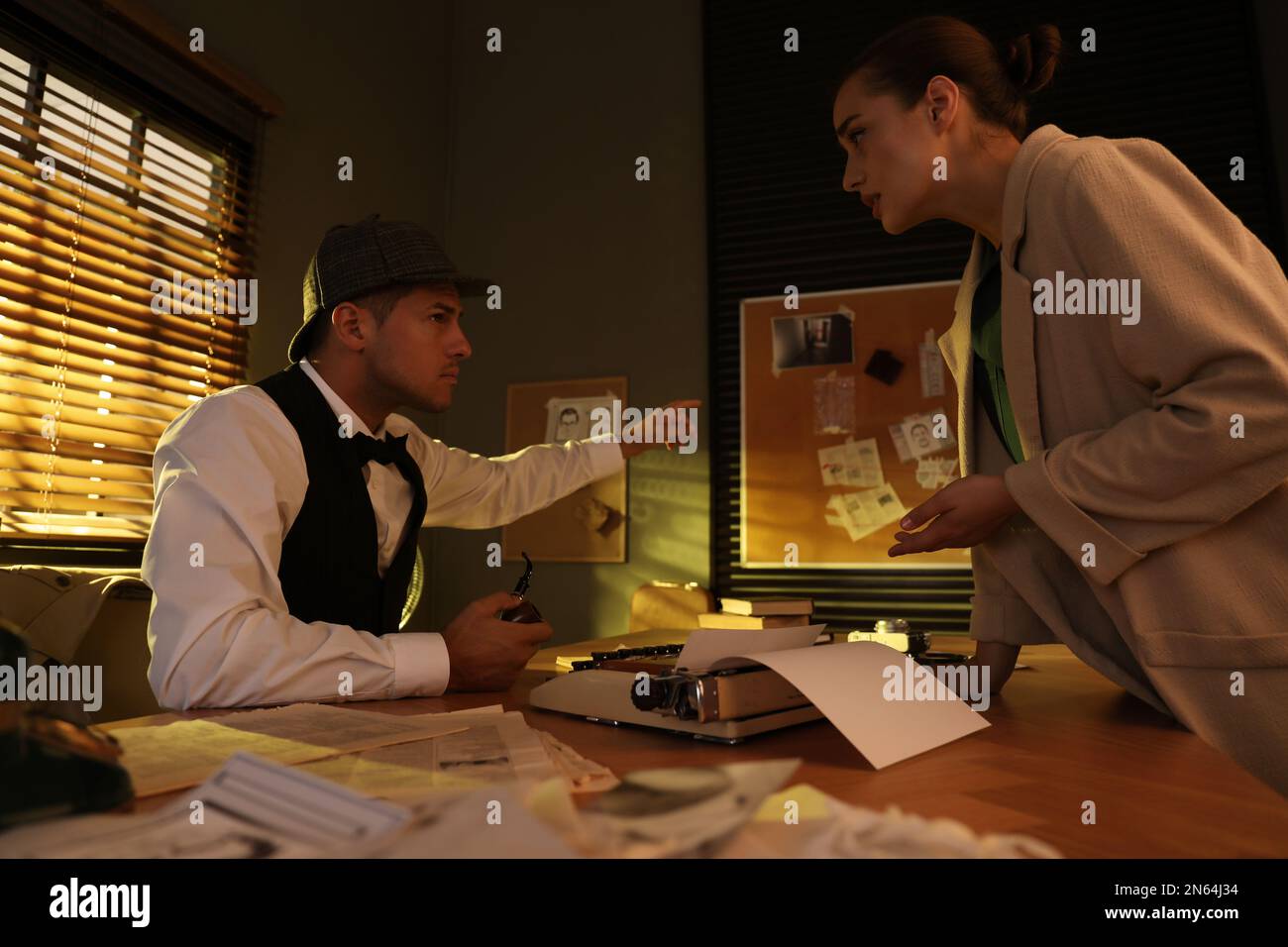 Old fashioned detective working with client in office Stock Photo - Alamy