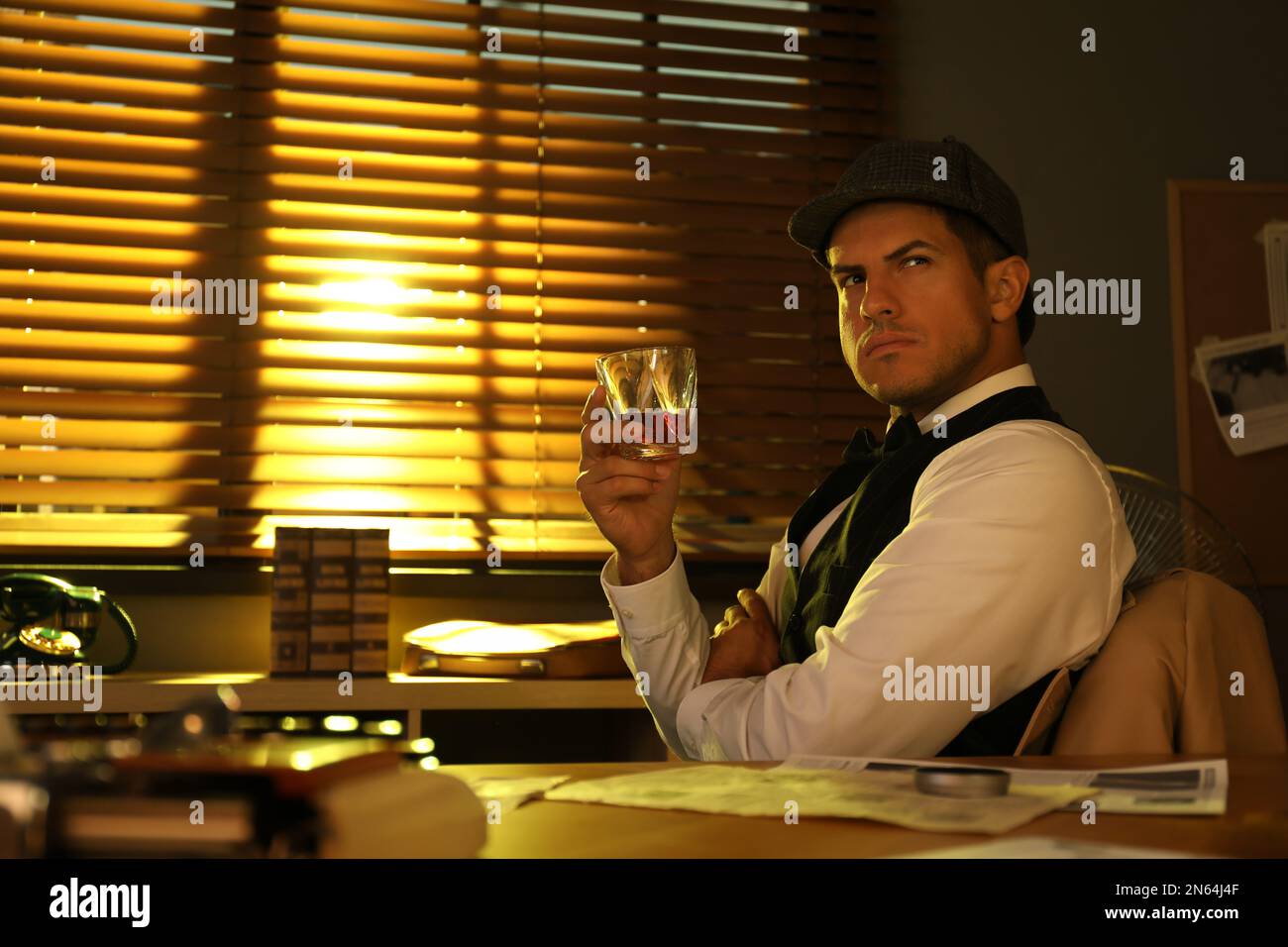Old fashioned detective with drink at table in office Stock Photo - Alamy