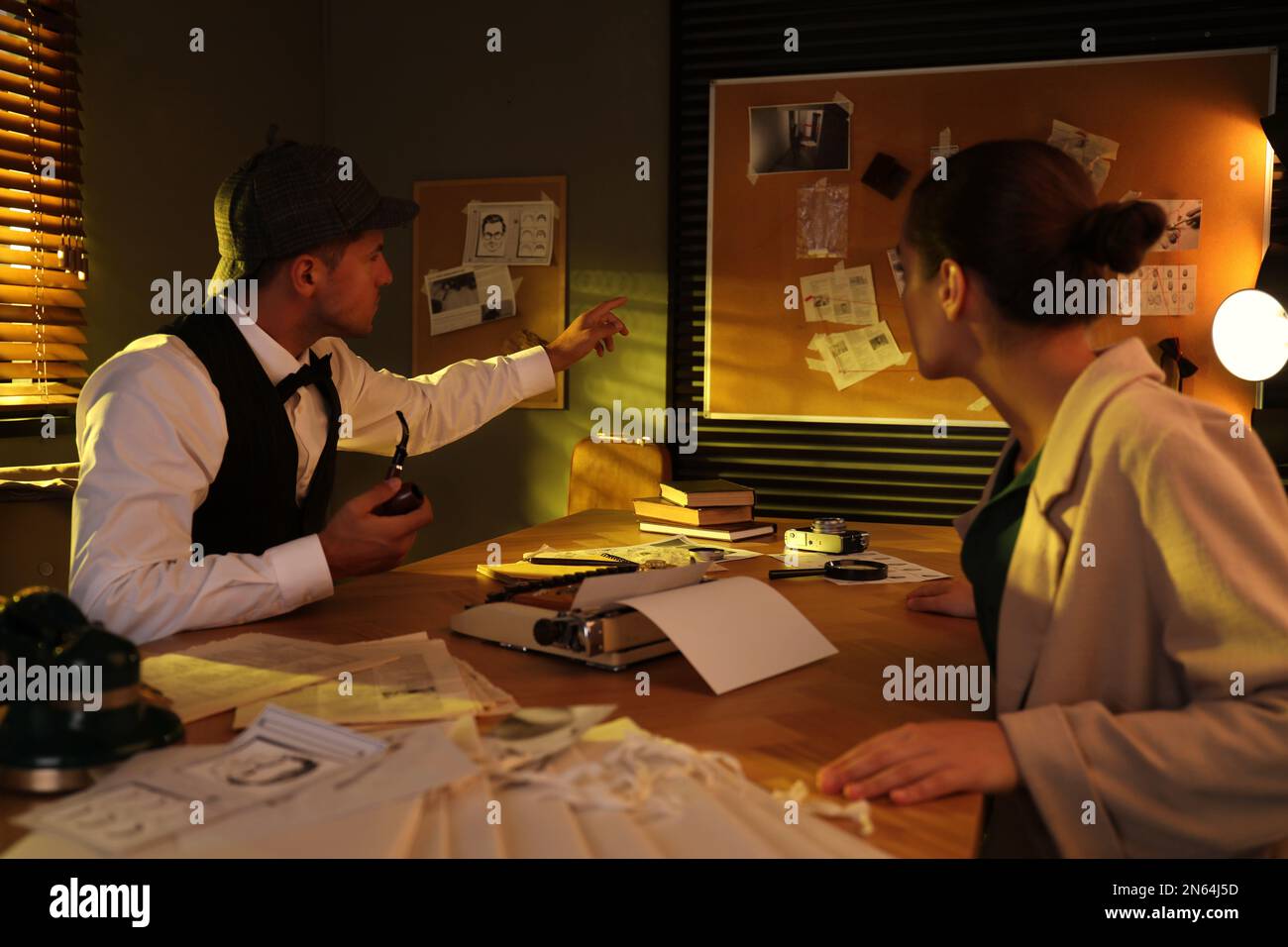 Old fashioned detective working with client in office Stock Photo - Alamy