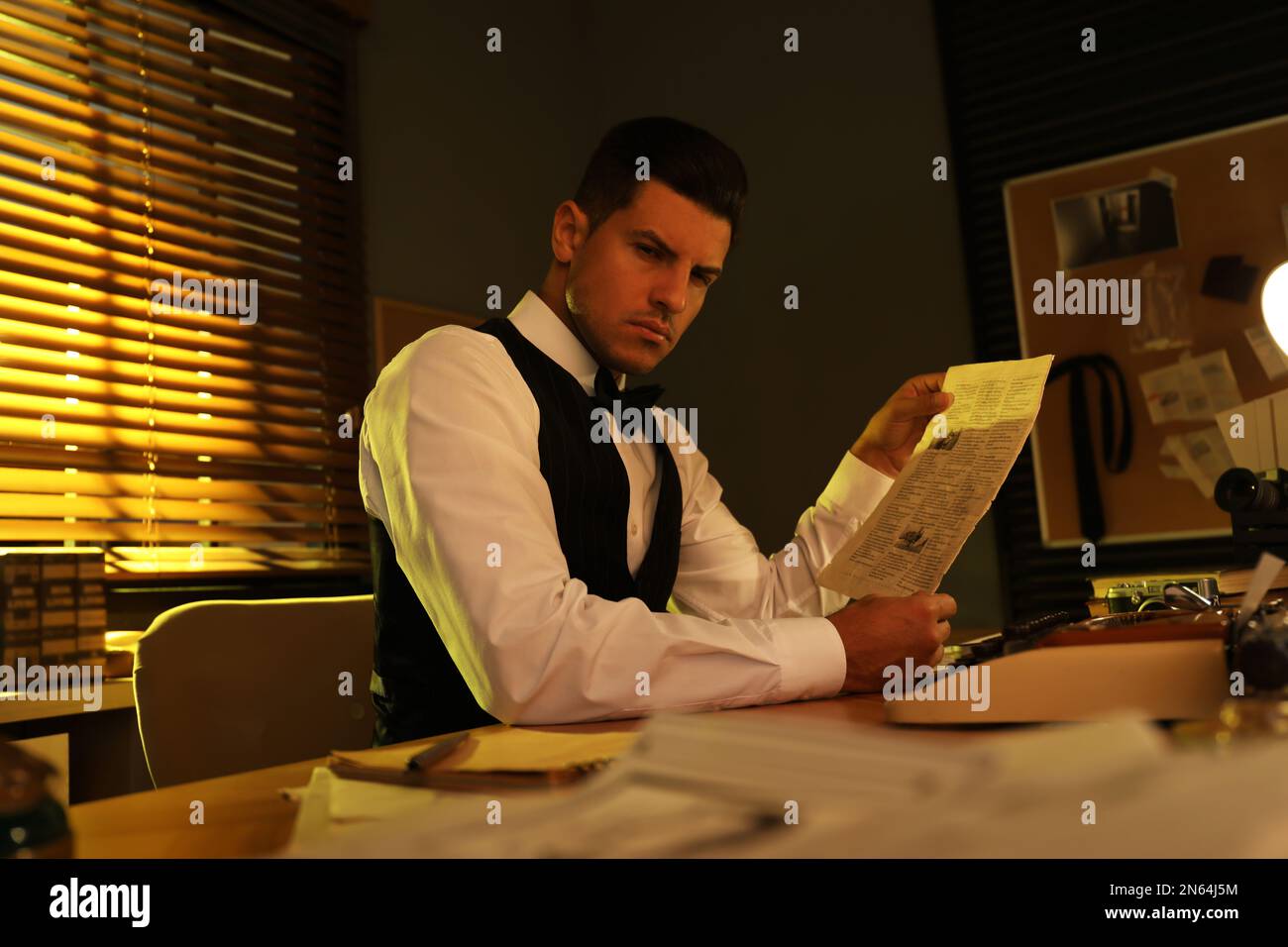 Old fashioned detective reading newspaper at table in office Stock ...