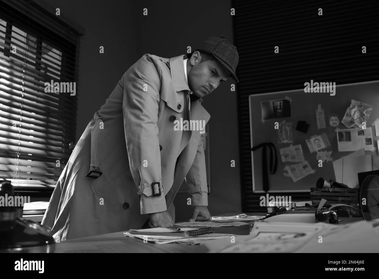 Old fashioned detective working in office. Black and white effect Stock ...