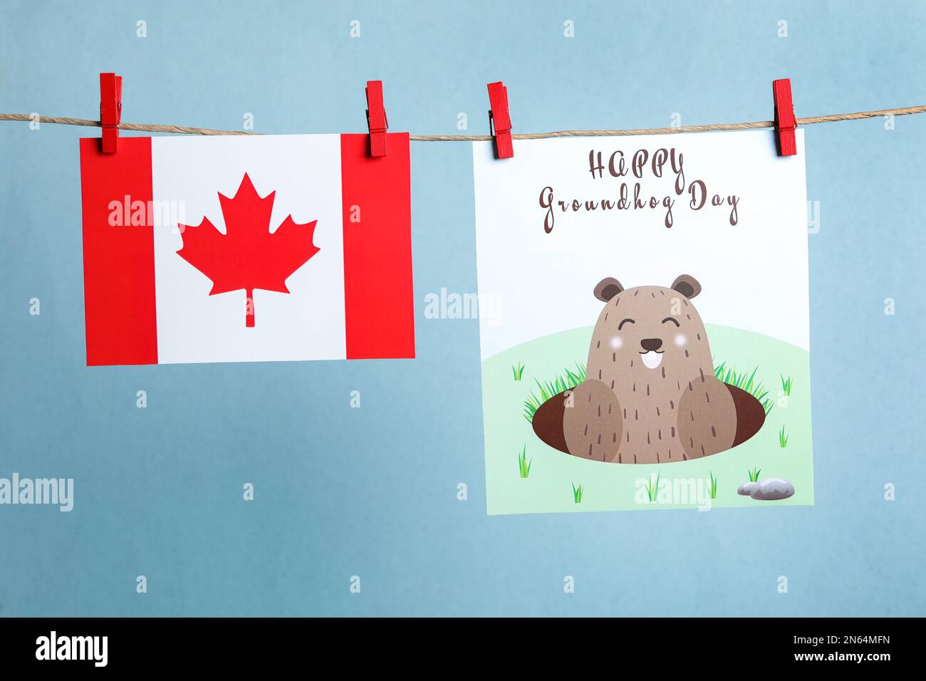 Happy Groundhog Day greeting card and Canada flag hanging on light blue ...