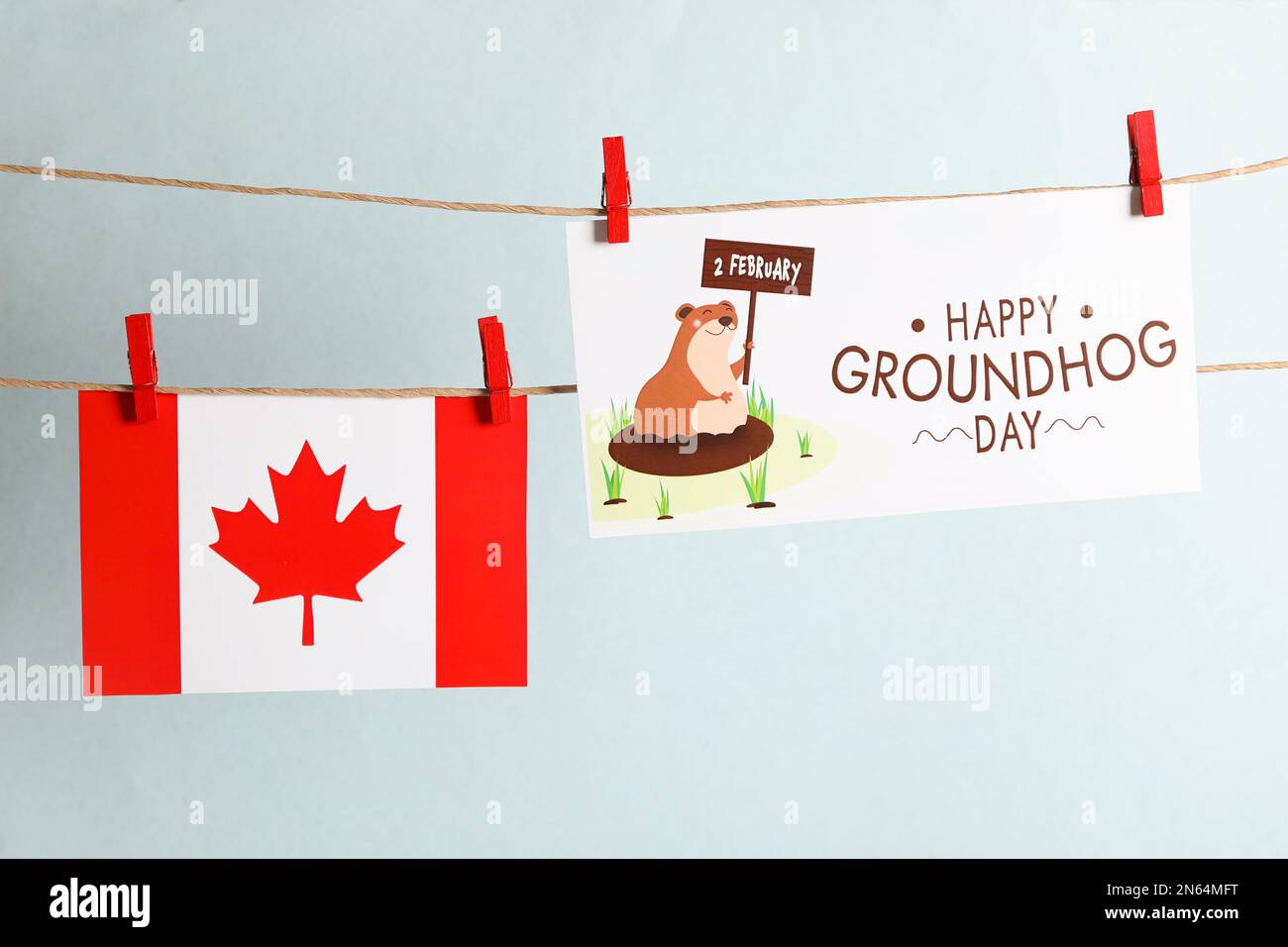 Happy Groundhog Day greeting card and Canada flag hanging against light ...