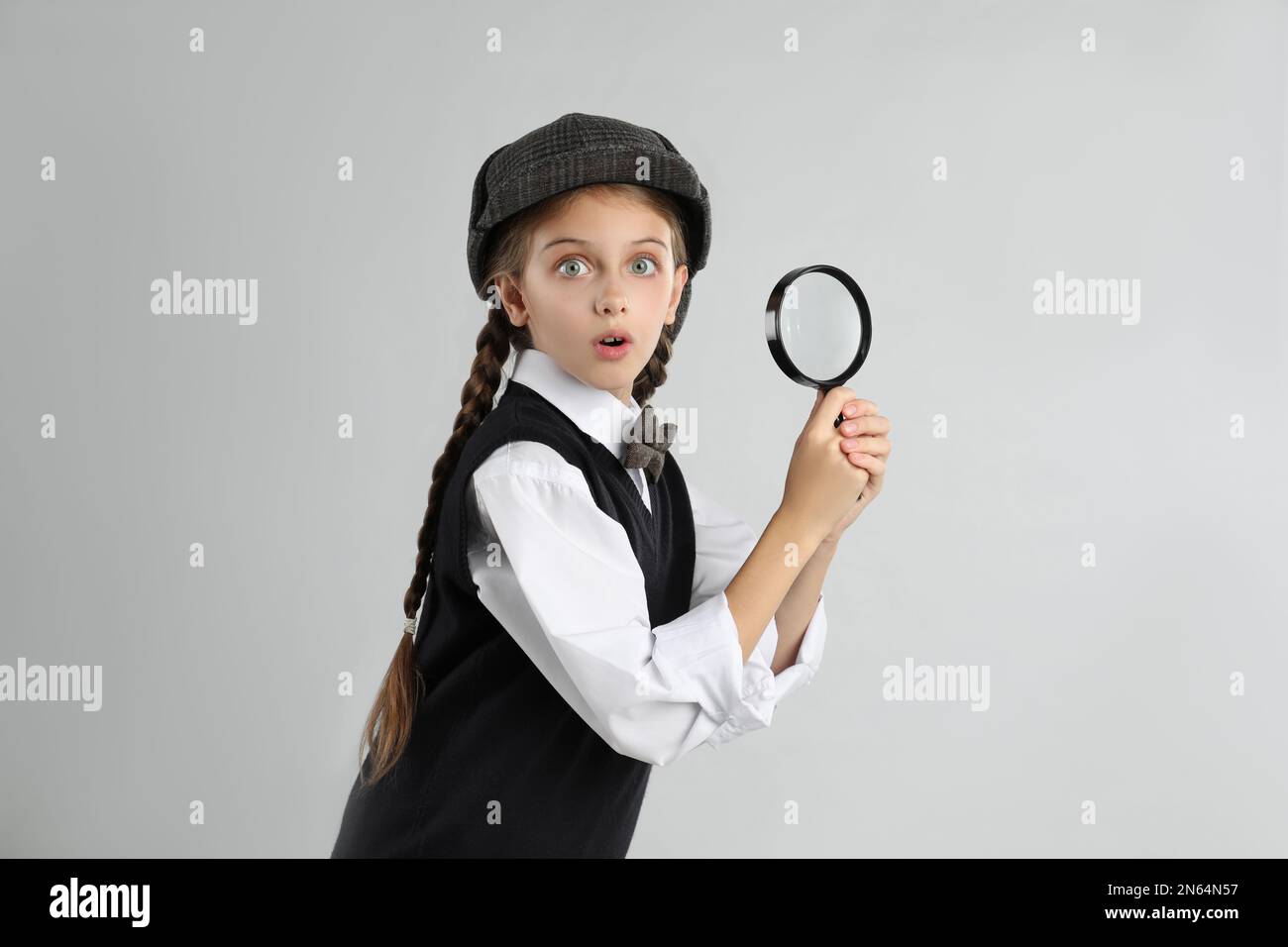 Cute little detective with magnifying glass on grey background Stock ...