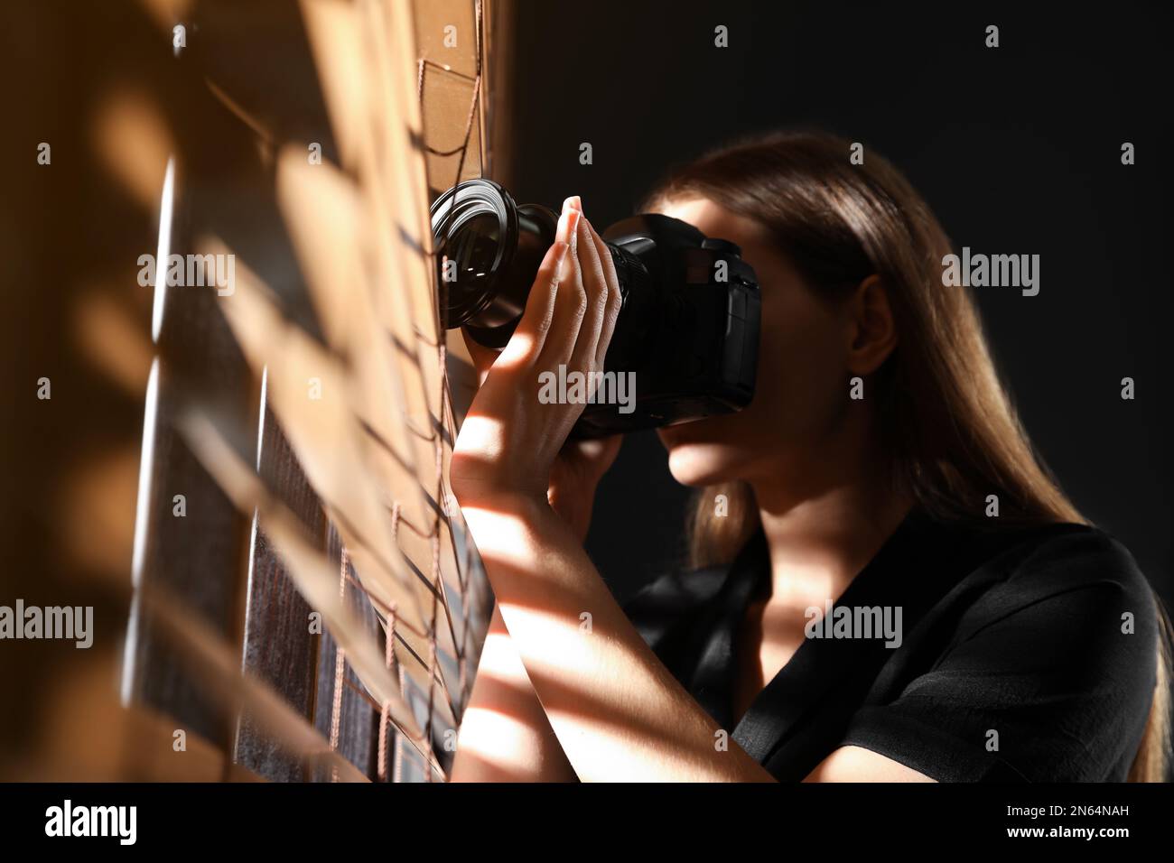 Private detective with camera spying near window indoors Stock Photo - Alamy