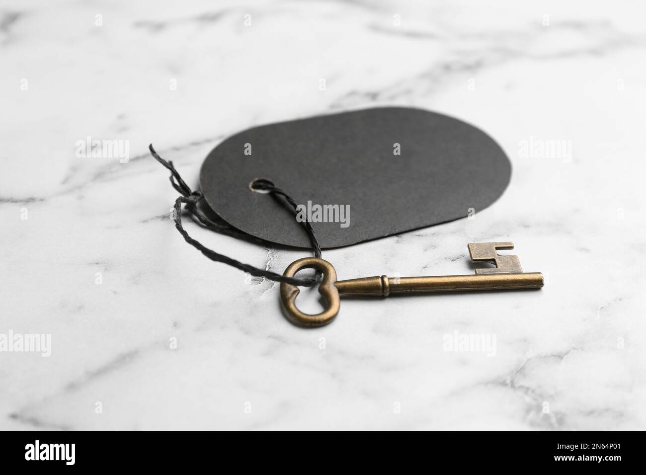 Vintage key with blank tag on white marble table. Keyword concept Stock ...