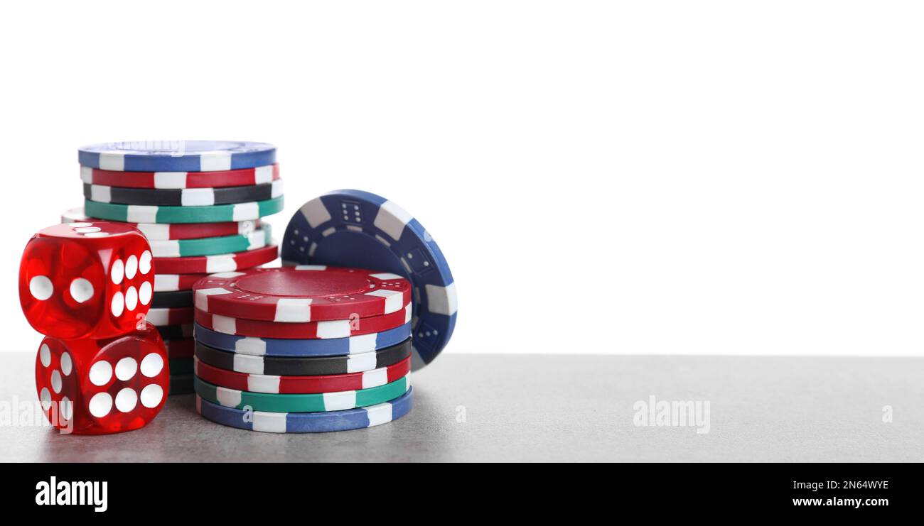 Gaming chips and dice on table against white background Stock Photo - Alamy