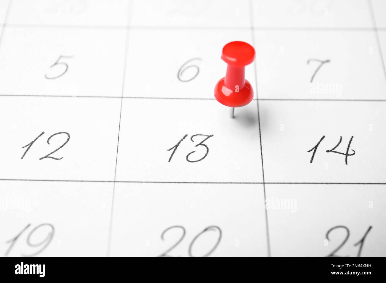 Calendar page with pin on Friday 13, closeup. Bad luck superstition ...