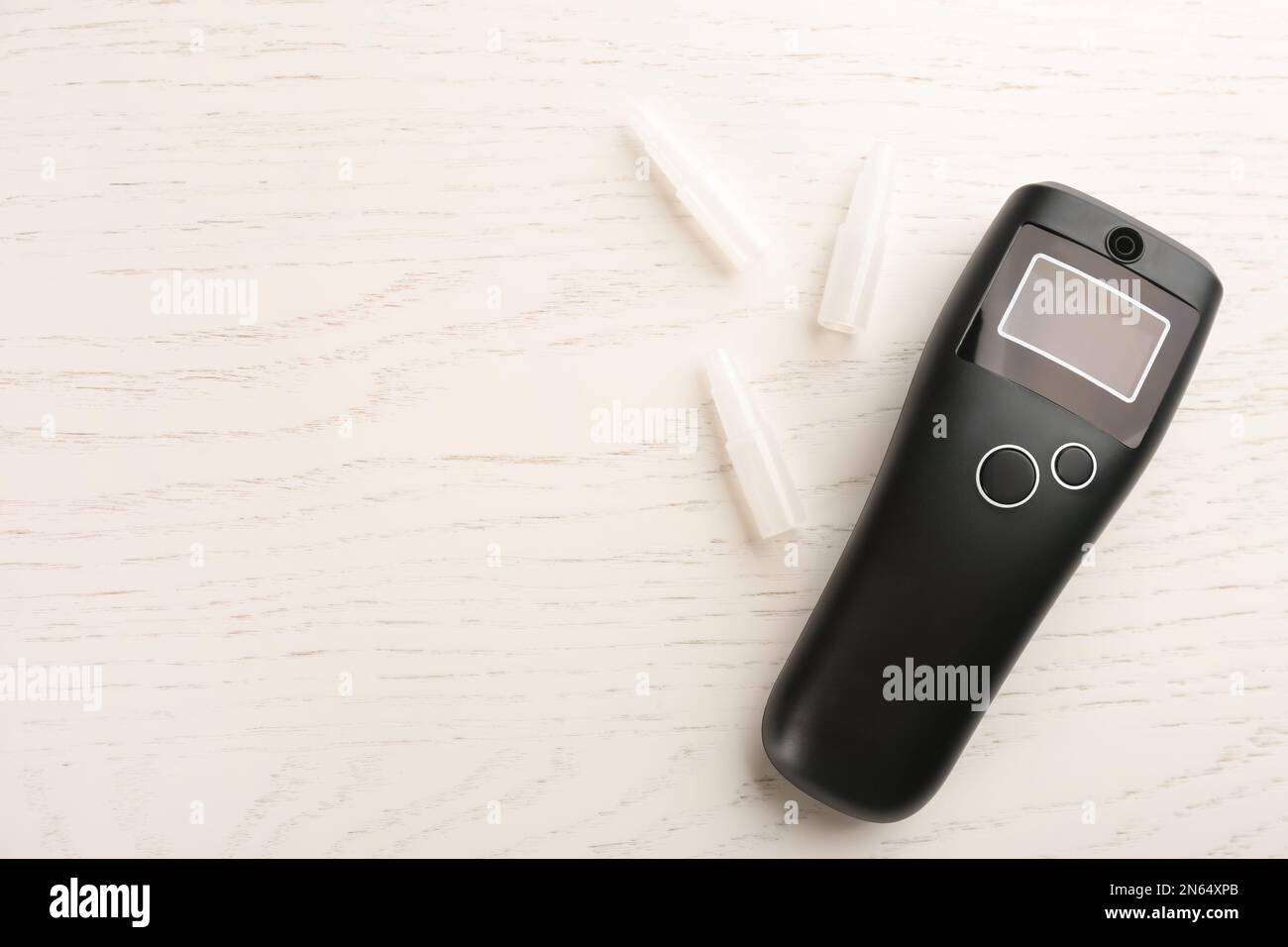 Modern breathalyzer with blank screen and mouthpieces on white wooden ...