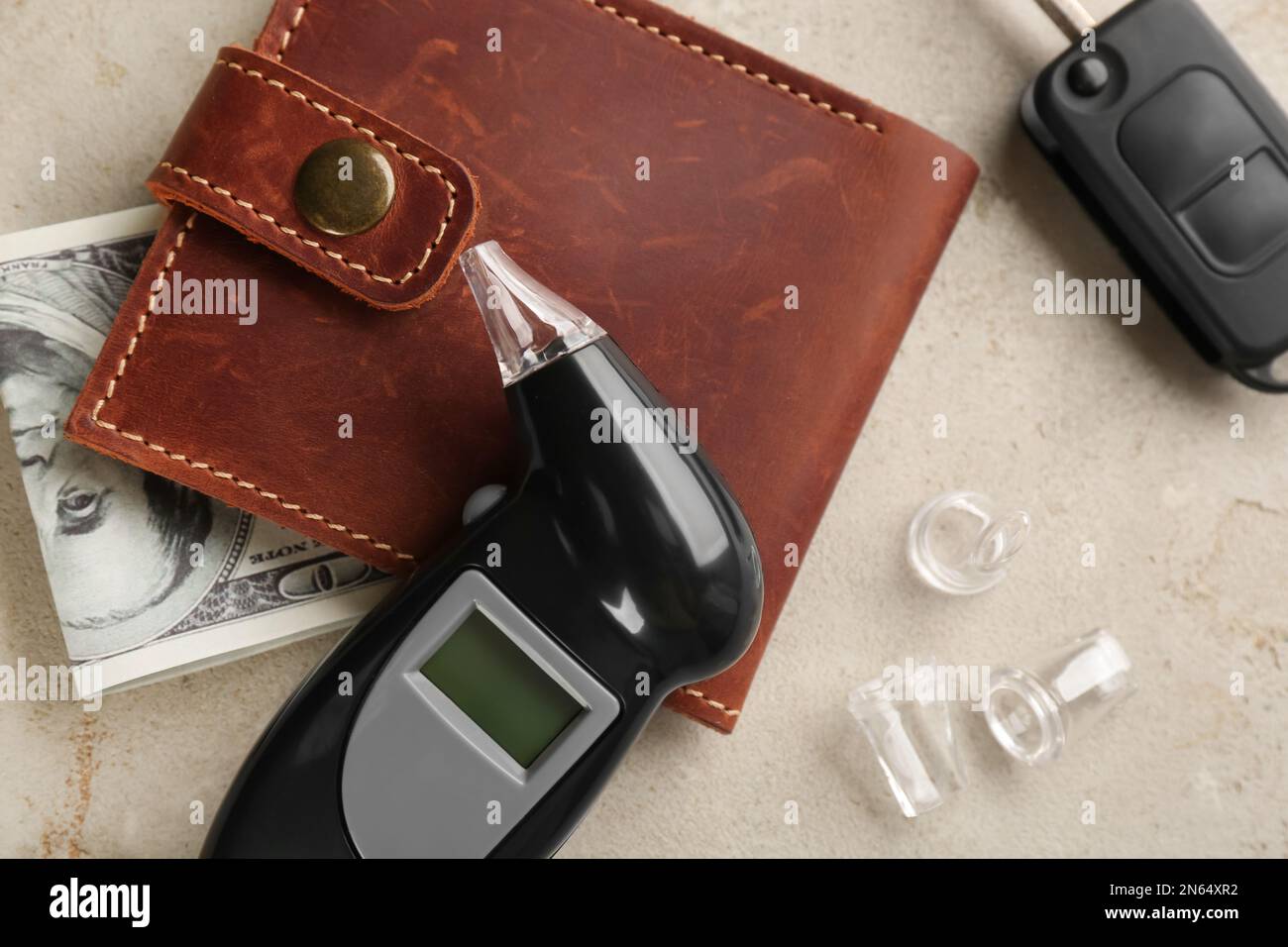 Flat lay composition with modern breathalyzer on light grey stone table ...