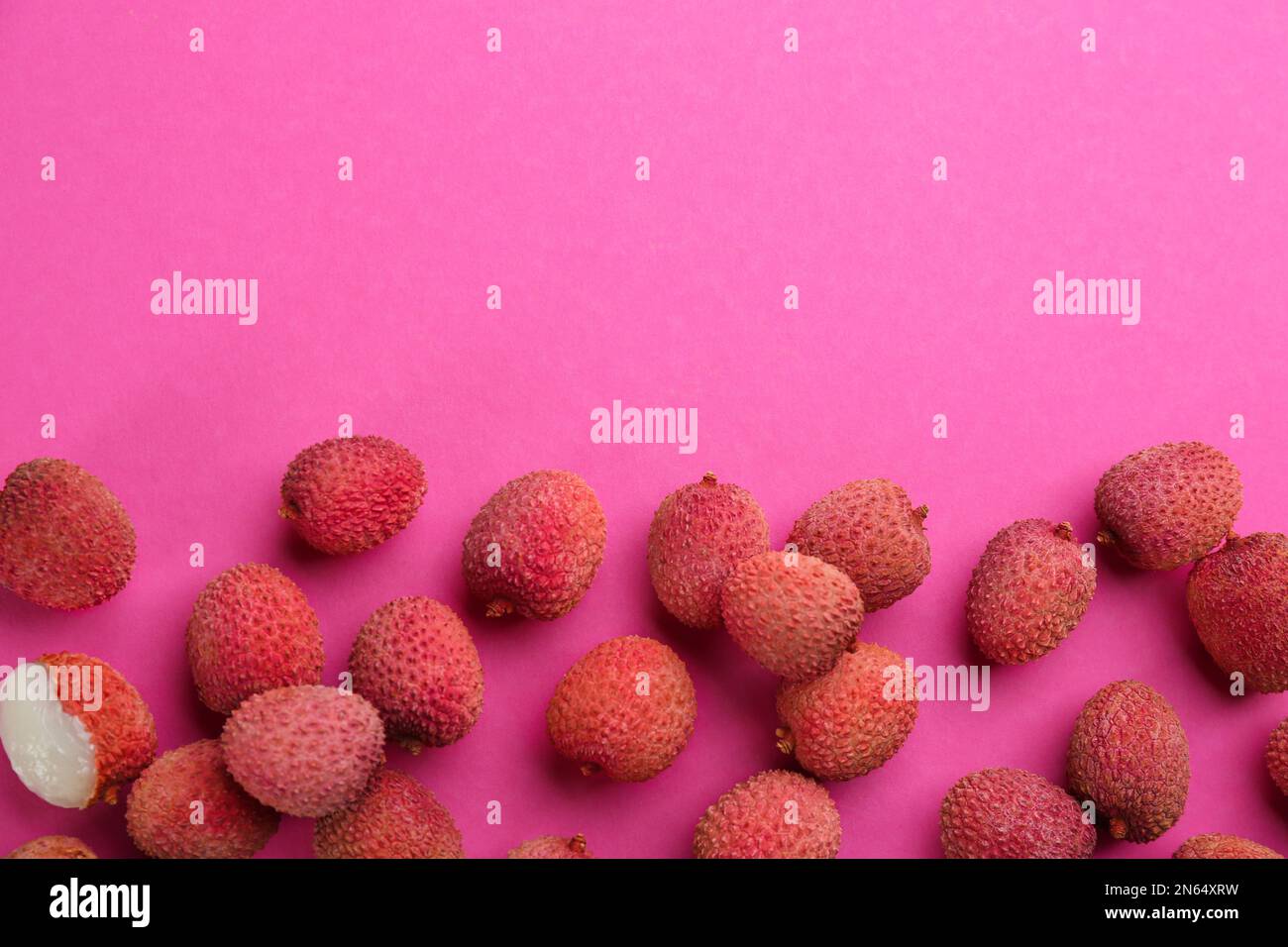 Fresh ripe lychees on pink background, flat lay. Space for text Stock ...