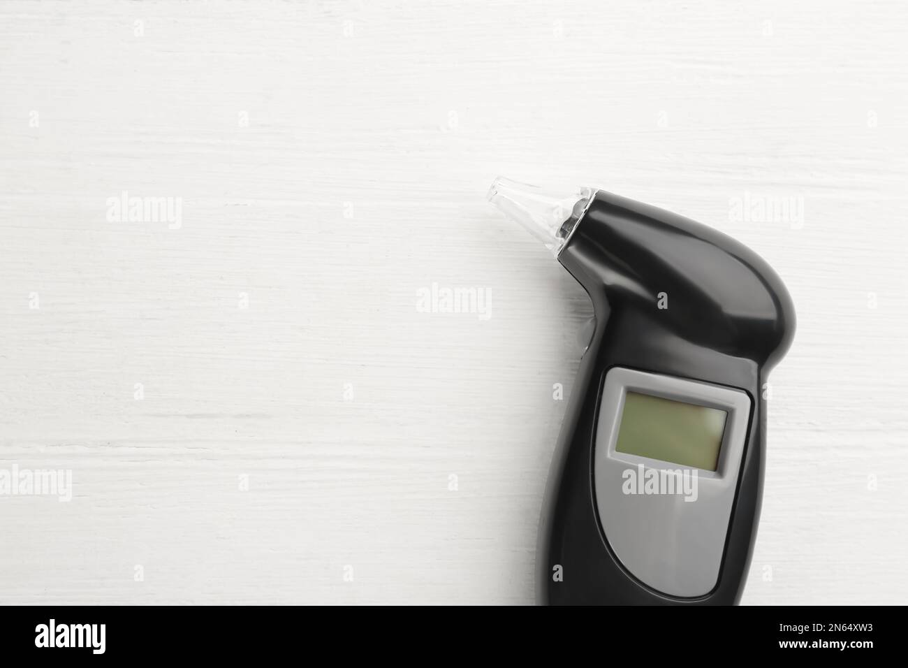 Modern breathalyzer on white wooden background, top view. Space for ...
