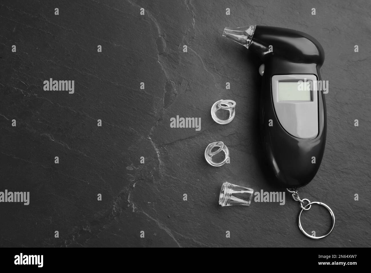 Modern breathalyzer and mouthpieces on black background, flat lay ...