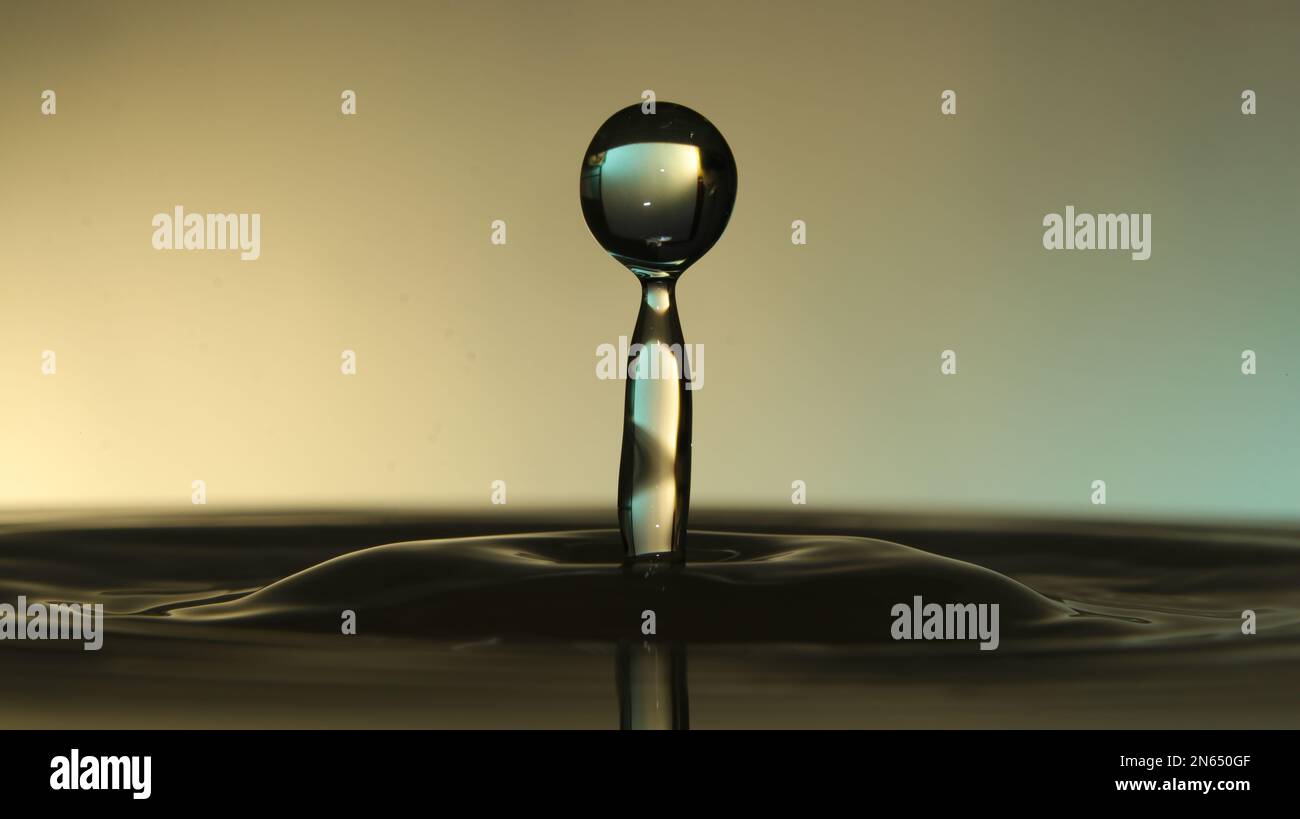Macro photograph of a water droplet splash captured mid-air above the ...