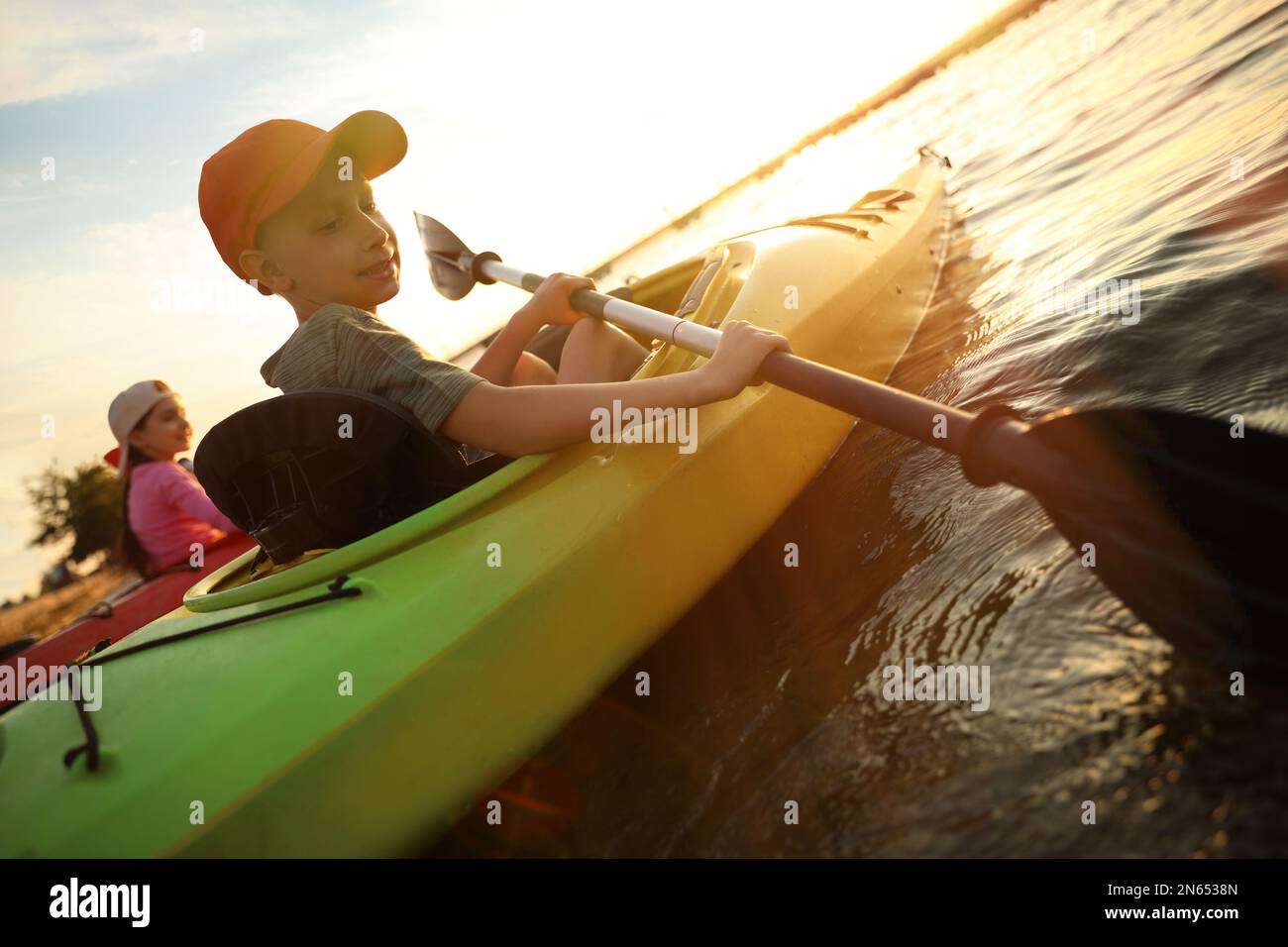 Happy children kayaking on river at sunset. Summer camp activity Stock ...