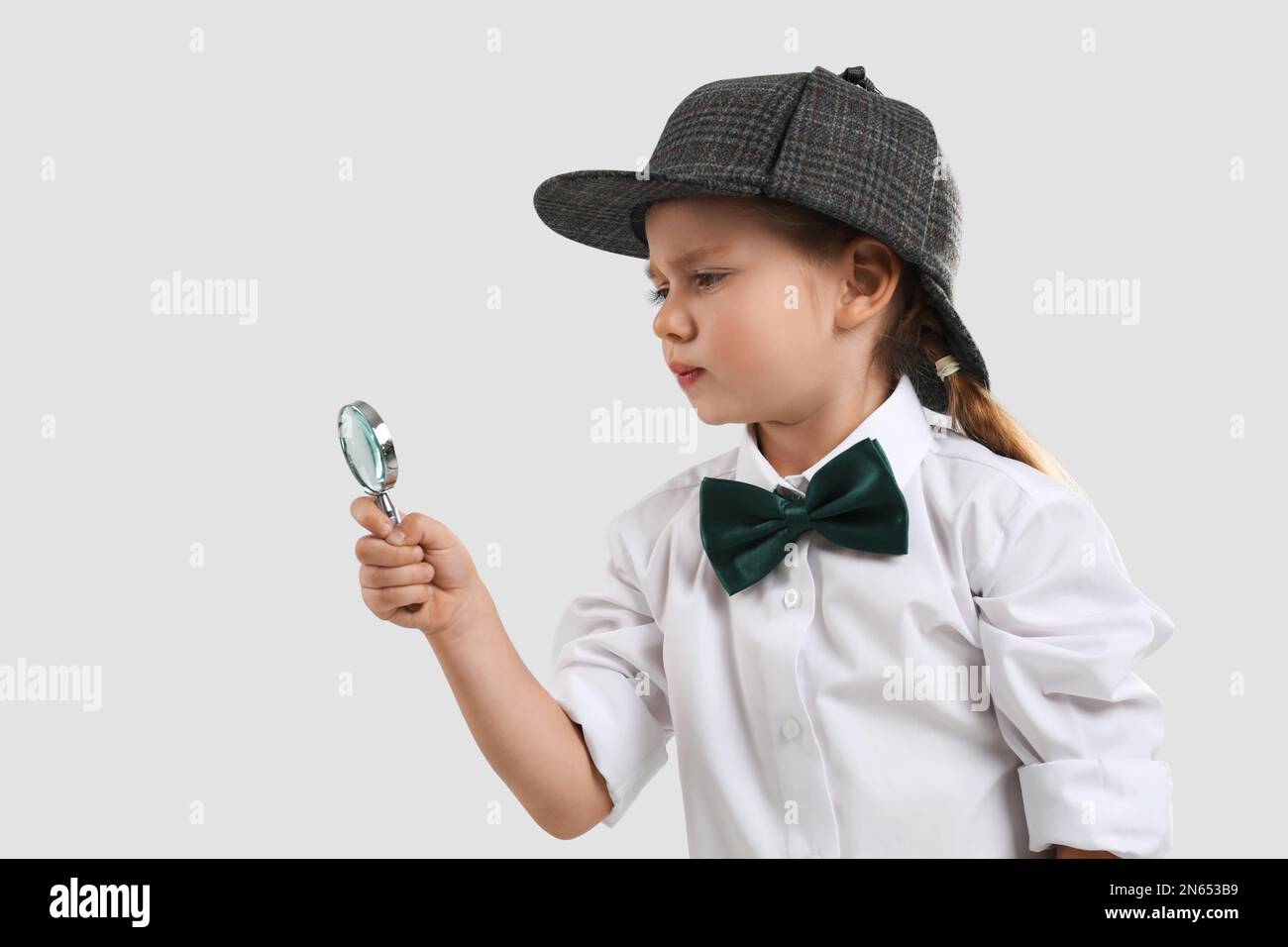 Cute little detective with magnifying glass on grey background Stock ...