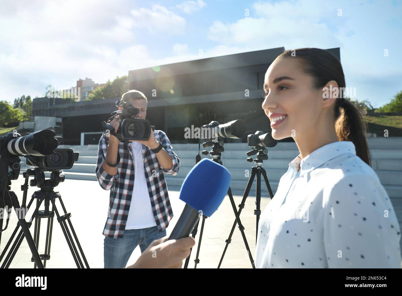 Professional journalist and operator with video camera taking interview ...