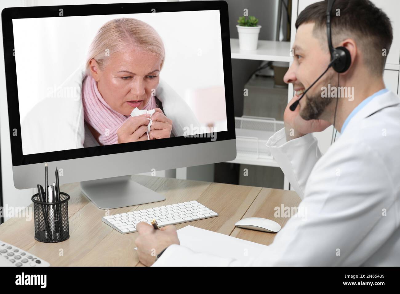 Hotline service. Doctor consulting patient online via computer indoors ...