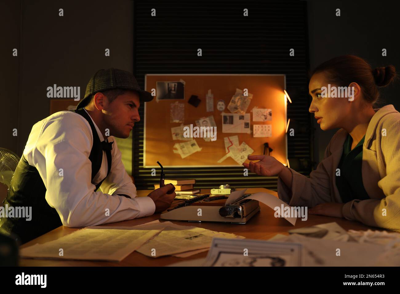 Old fashioned detective working with client in office Stock Photo - Alamy